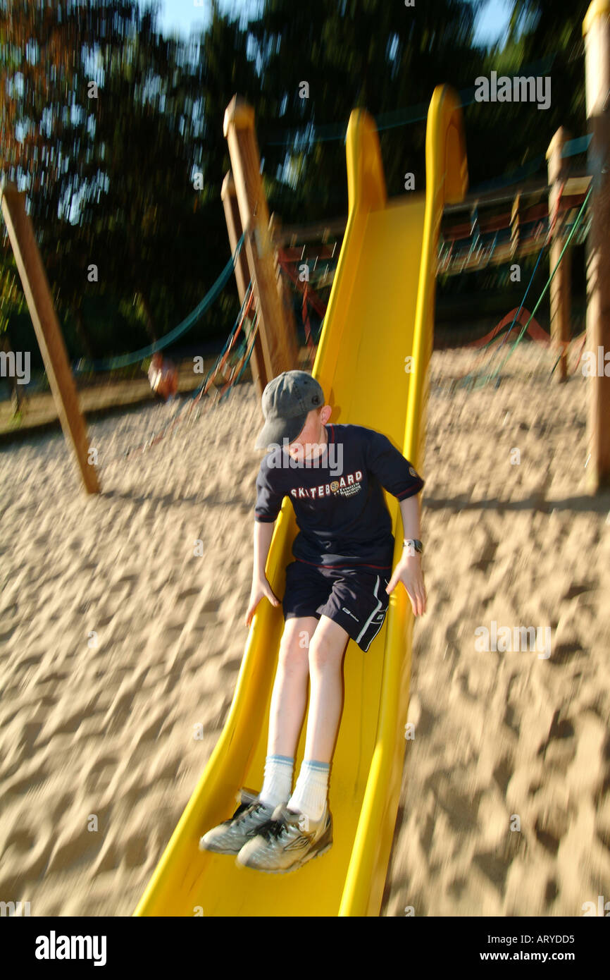 Boy playing on slide Stock Photo - Alamy