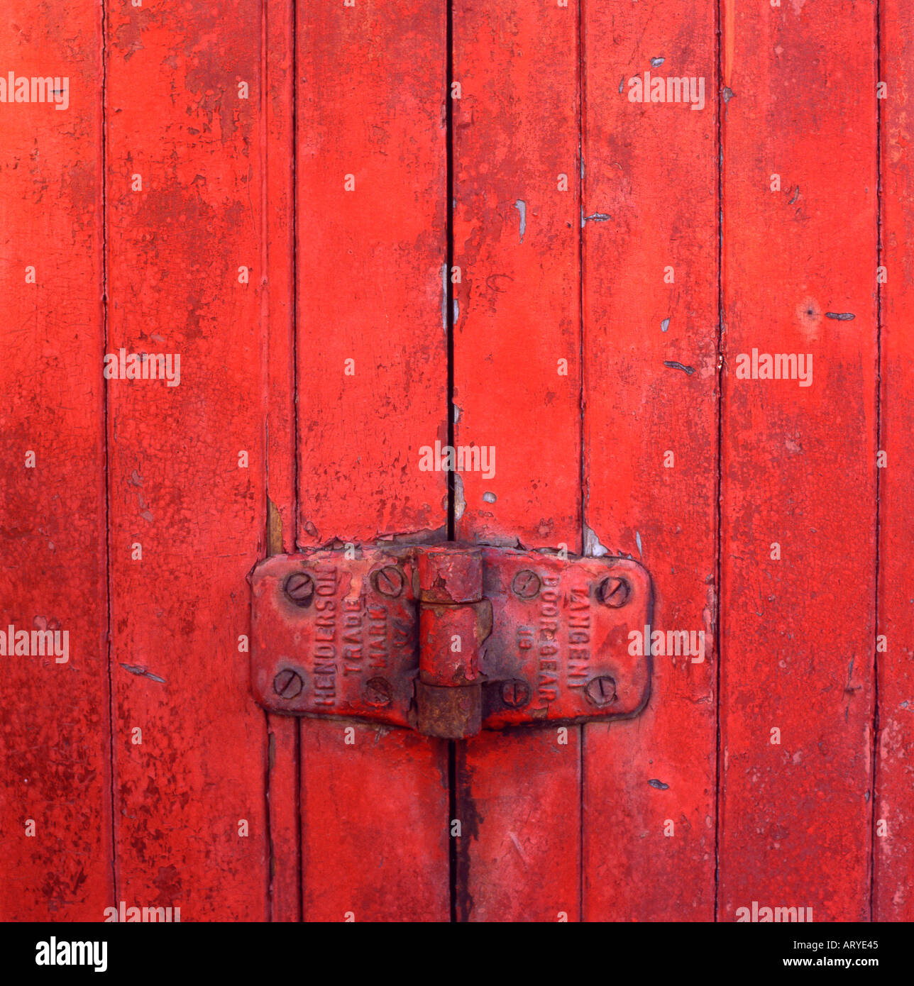 Rusty hinge on red wooden door Laugharne Wales UK Stock Photo - Alamy