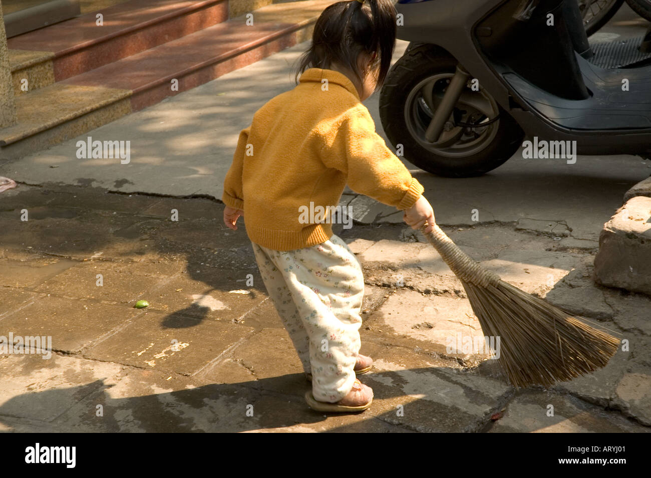 Little girl sweeping outside her home Hanoi Vietnam Stock Photo - Alamy