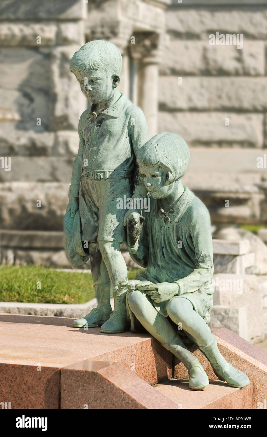 Bronze statues of children in 1920s clothes mourn at the tomb of a ...