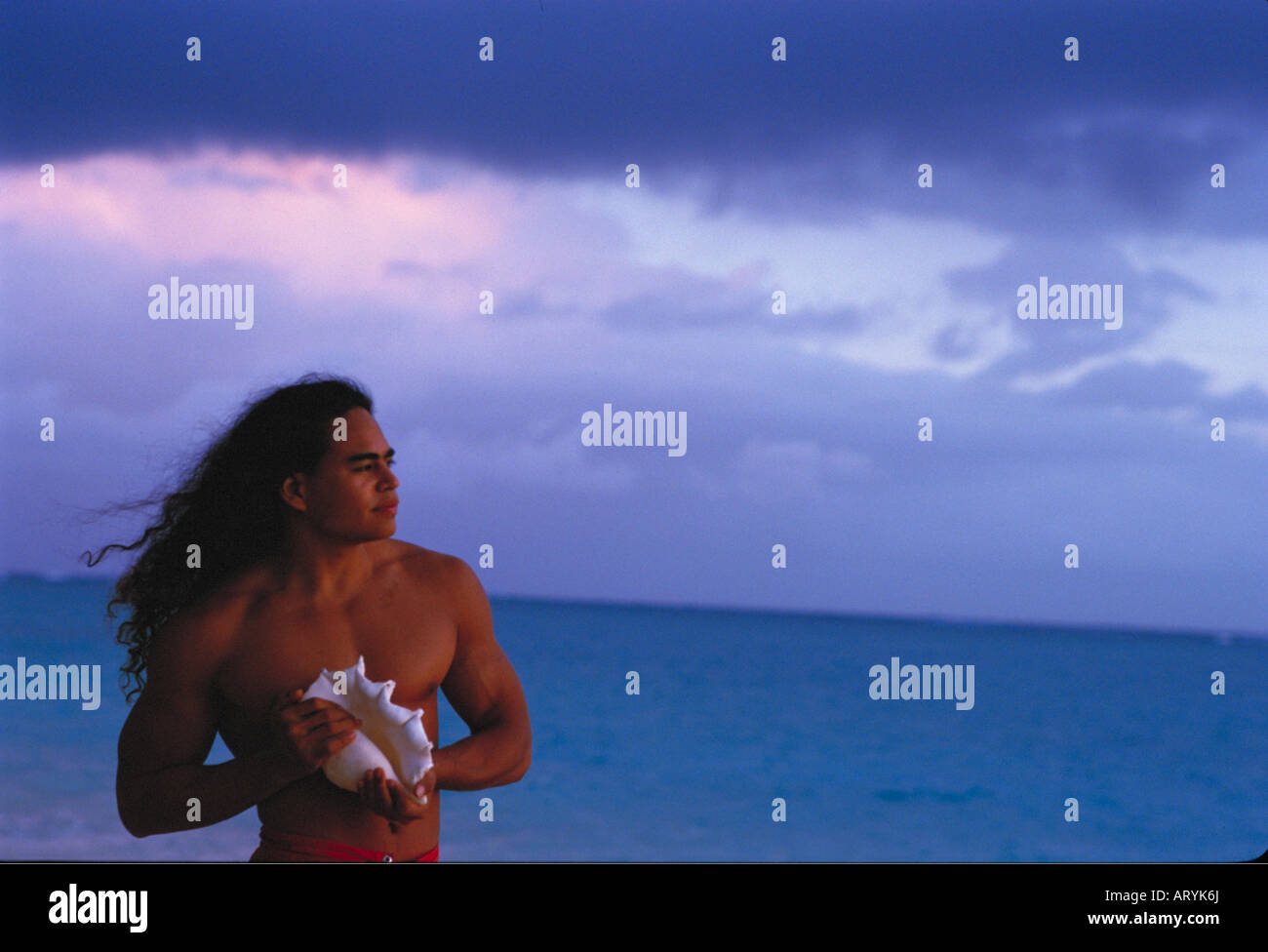 Young Hawaiian man at sunrise with conch shell Stock Photo - Alamy
