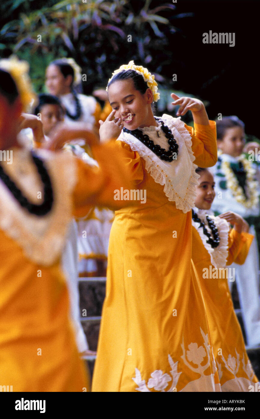 Young woman performing hula auwana (modern hula) with her hula halau ...