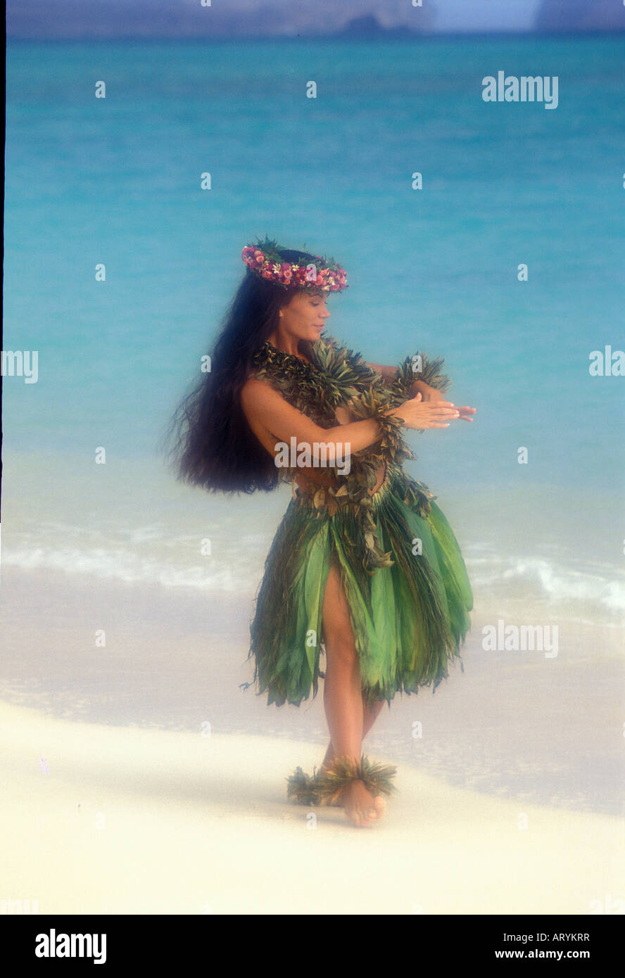 Woman dances hula at Kailua Beach in ti leaf skirt and leis. Oahu Stock ...