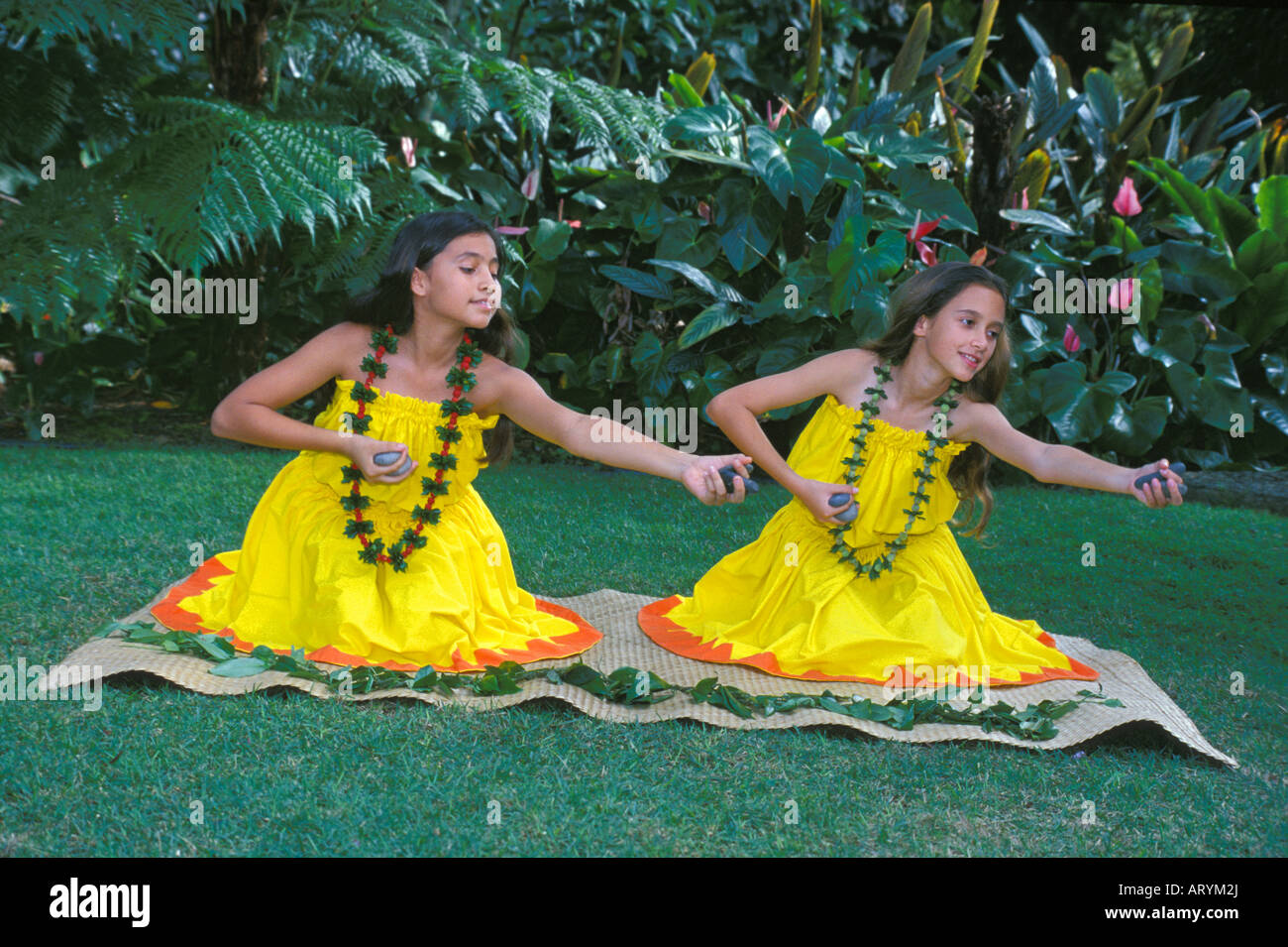 Two girls performing noho (seated) a hula with ili ili stones Stock ...