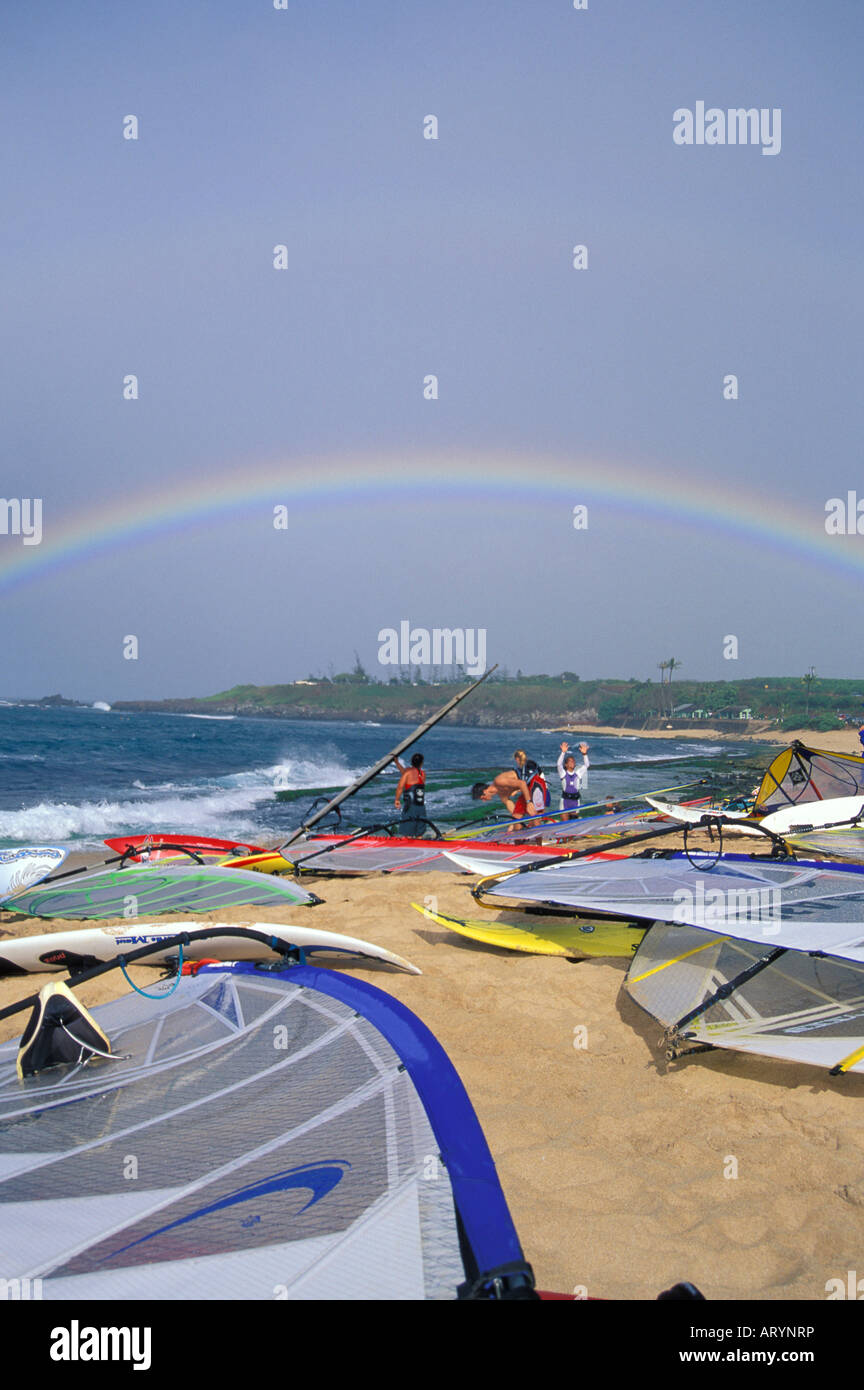 Windsurfers relaxing on Ho'okipa Beach Park with rainbow overhead.Just ...