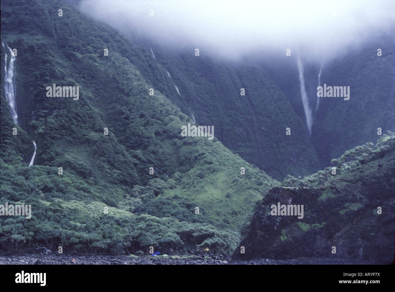 Camping under huge waterfalls in Molokai's remote Papalaua Valley Stock ...