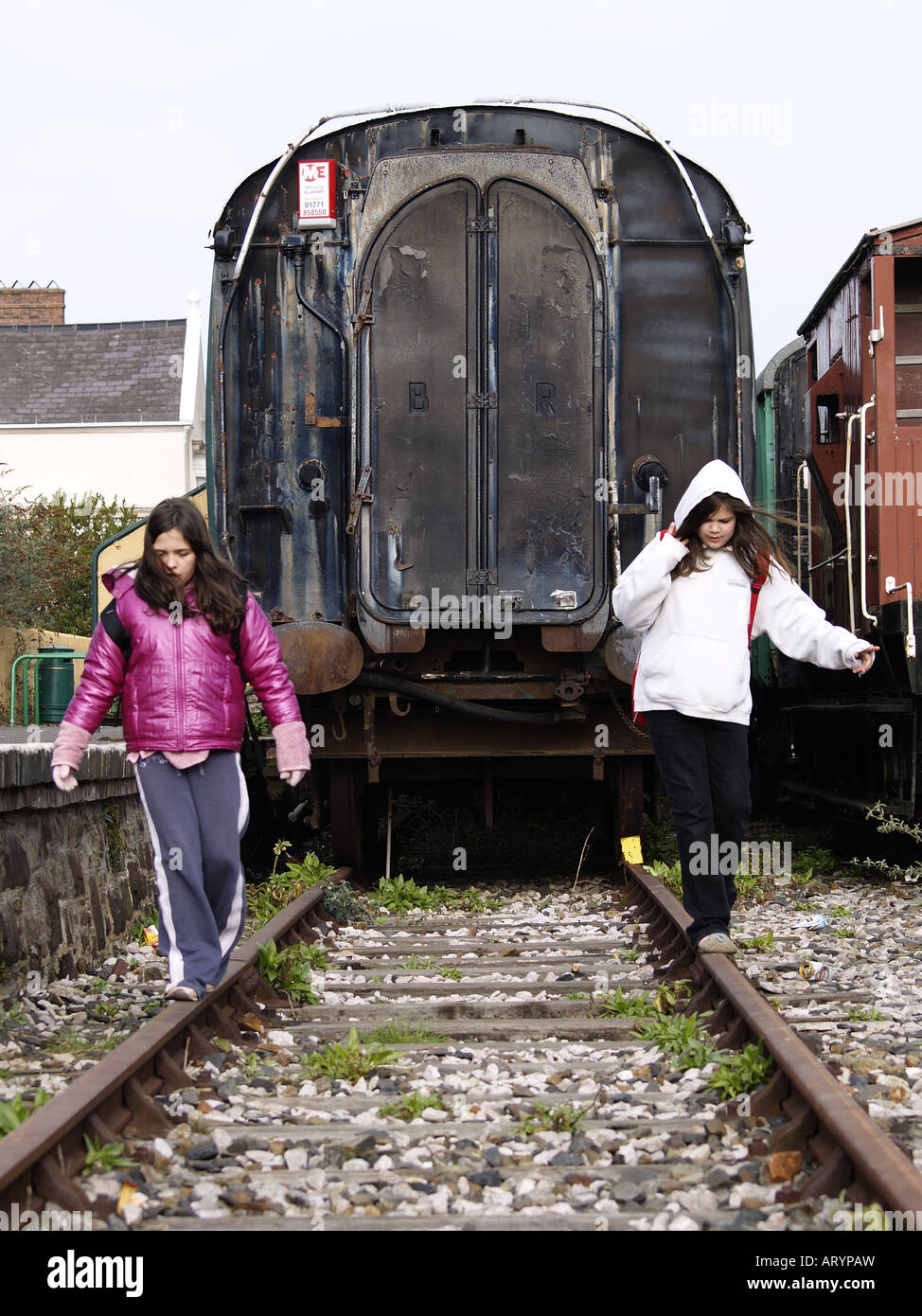 Two young girls walking along train tracks Stock Photo - Alamy