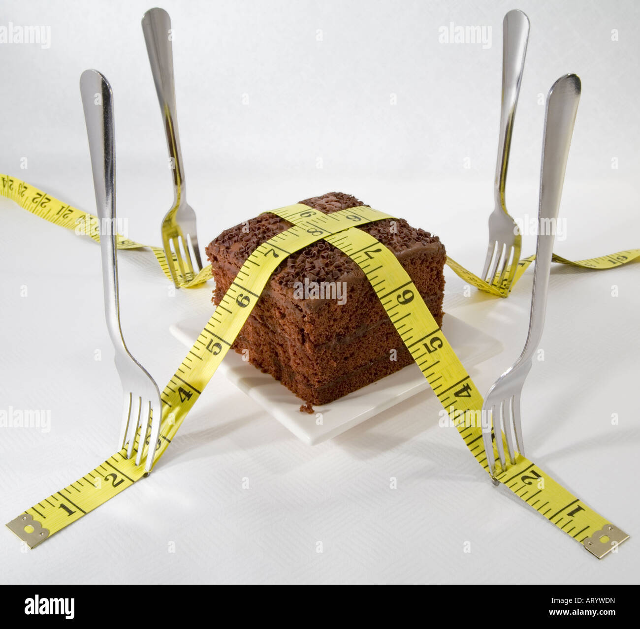 Chocolate cake held down with a tape measure and forks Stock Photo - Alamy