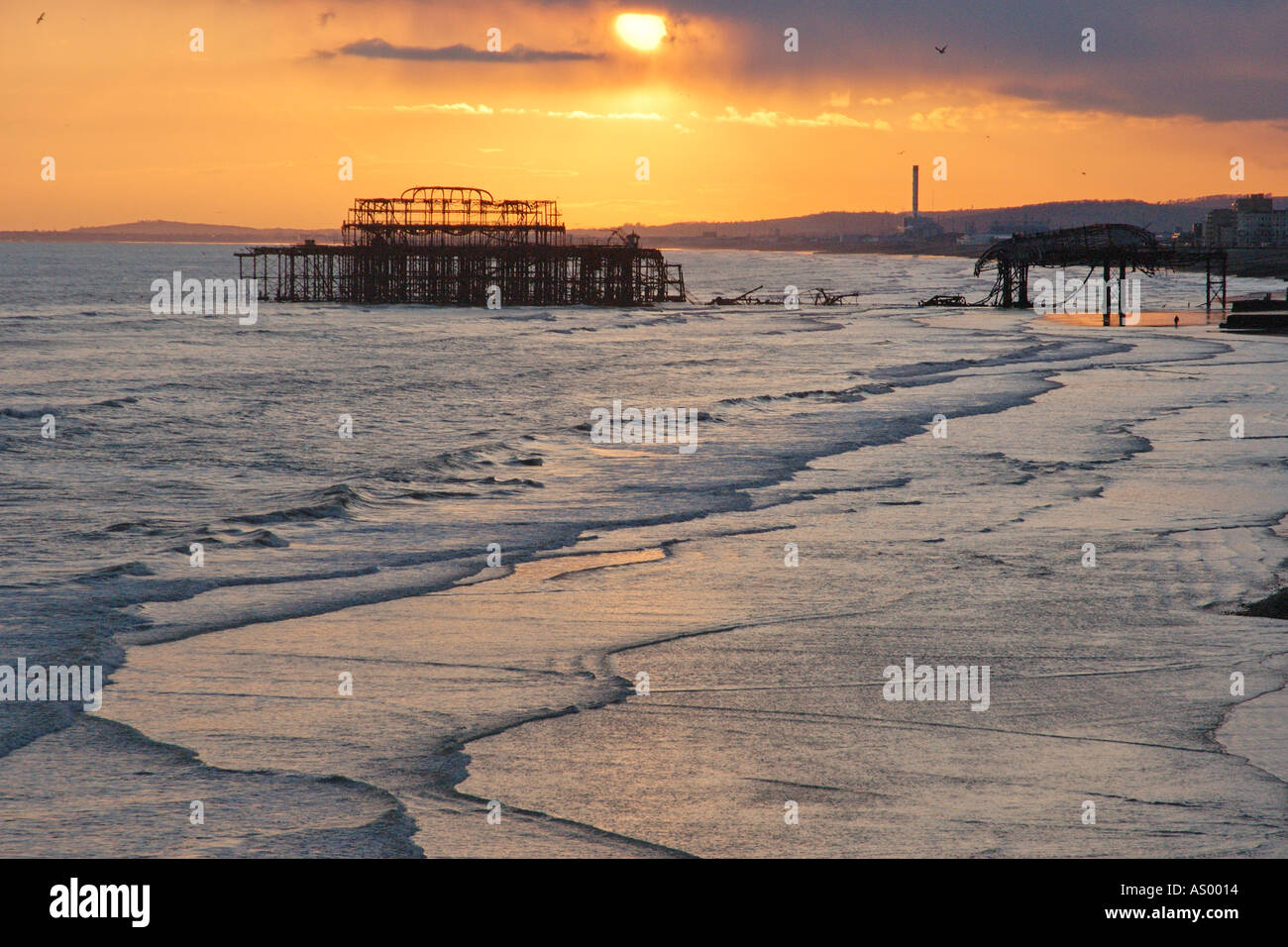 Wonderful sun set sun sinks into the water behind the ruined west pier ...