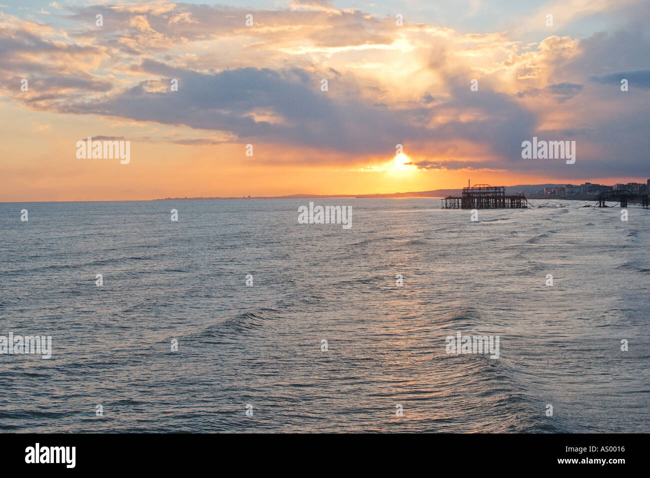 Wonderful sun set sun sinks into the water behind the ruined west pier ...