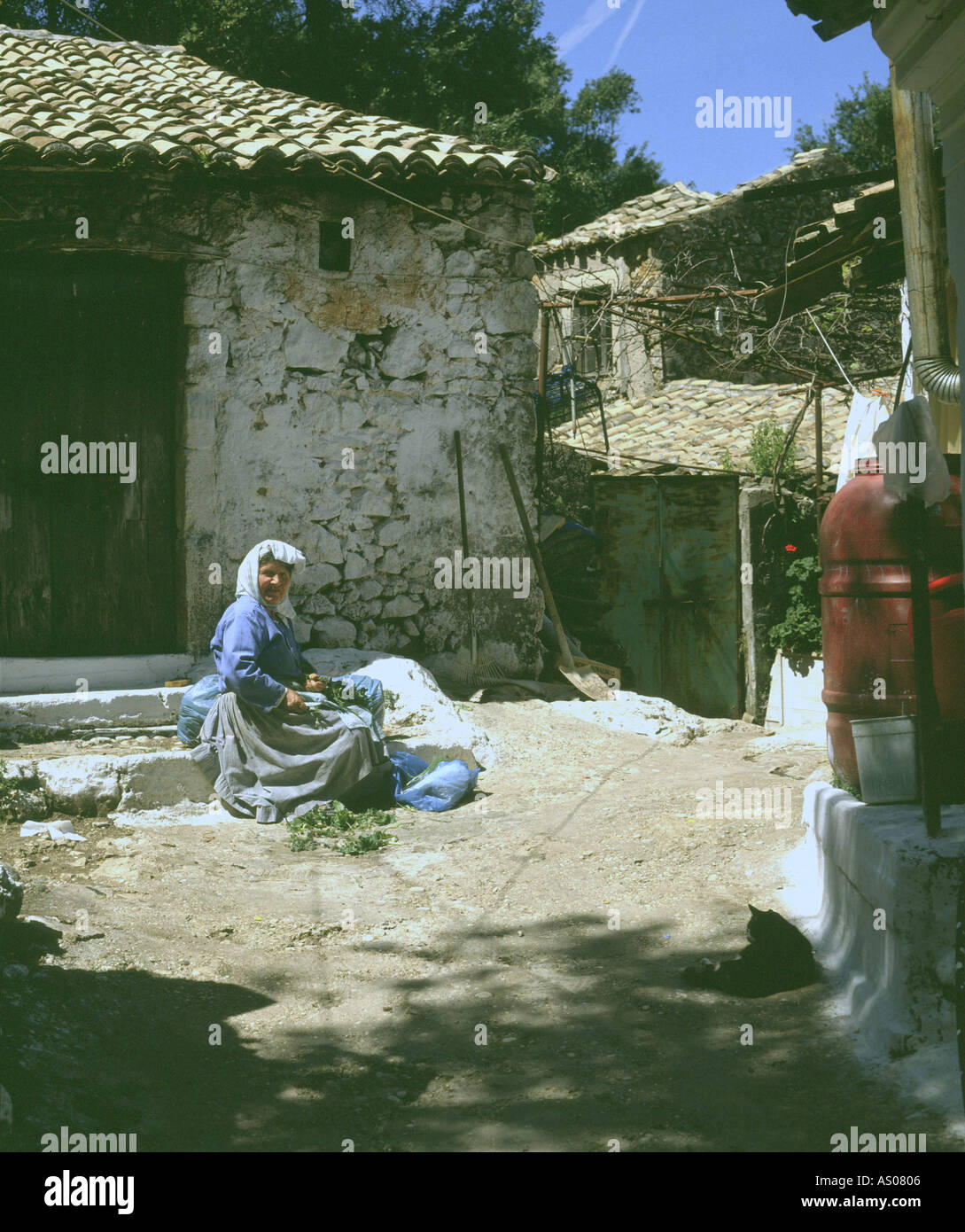 Corfu woman in courtyard Stock Photo - Alamy