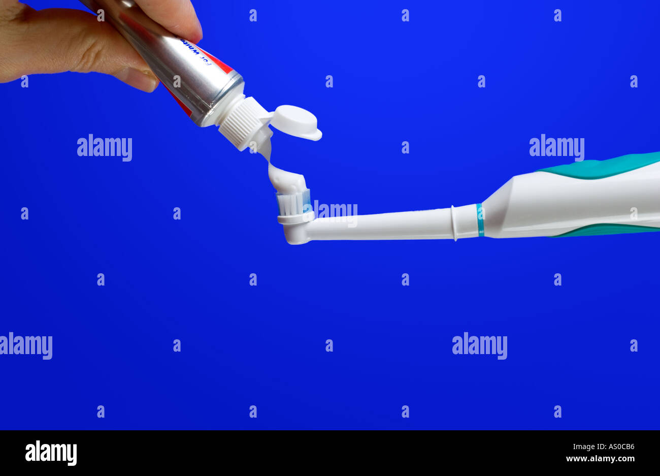squeezing toothpaste onto electric toothbrush Stock Photo - Alamy