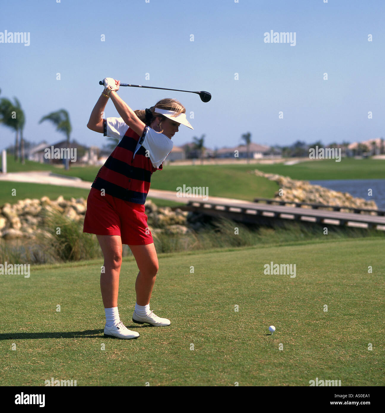 Female golfer teeing off Stock Photo - Alamy