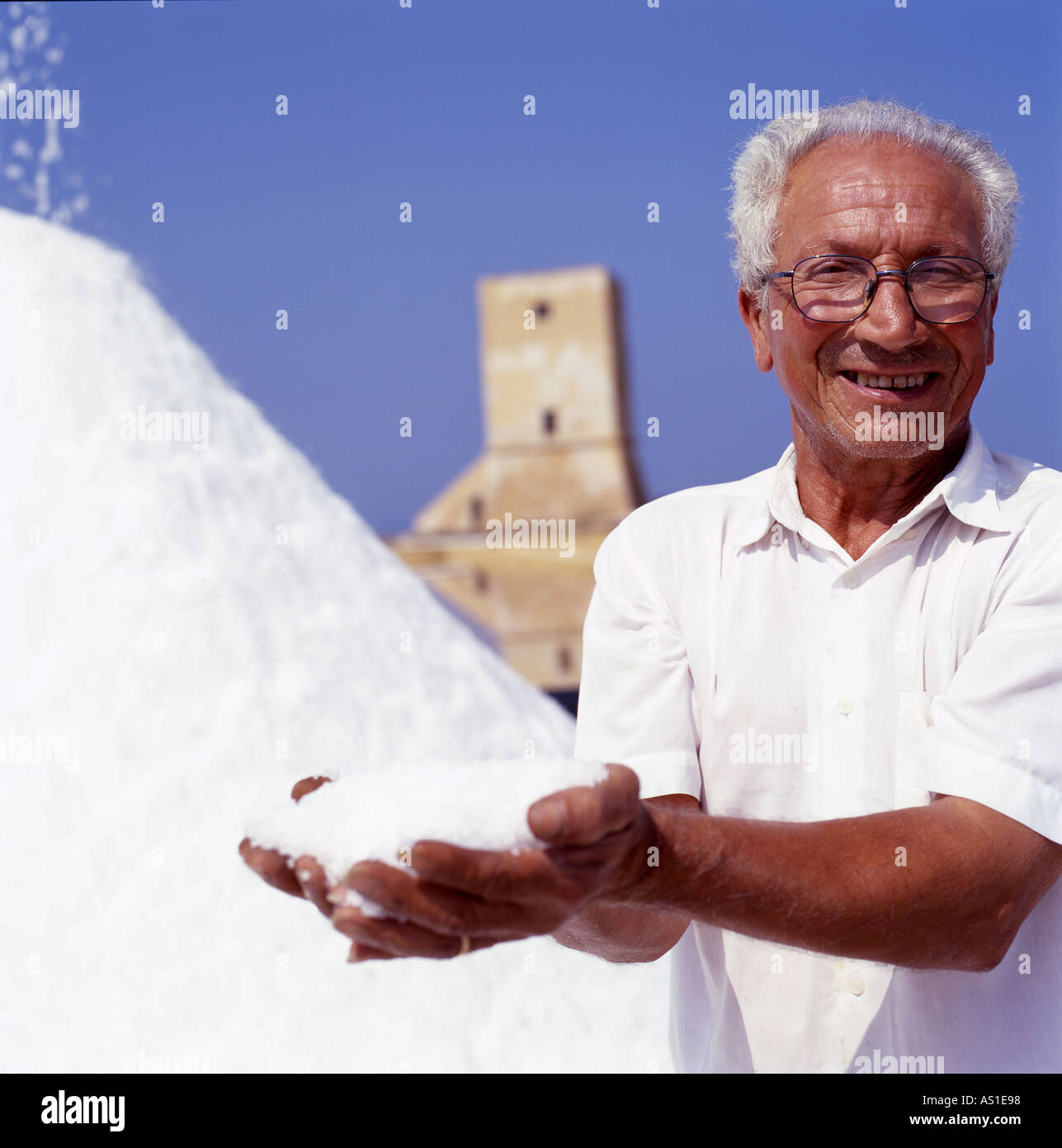 worker at a salt plan in the area of trapani holding salt sicily Stock ...
