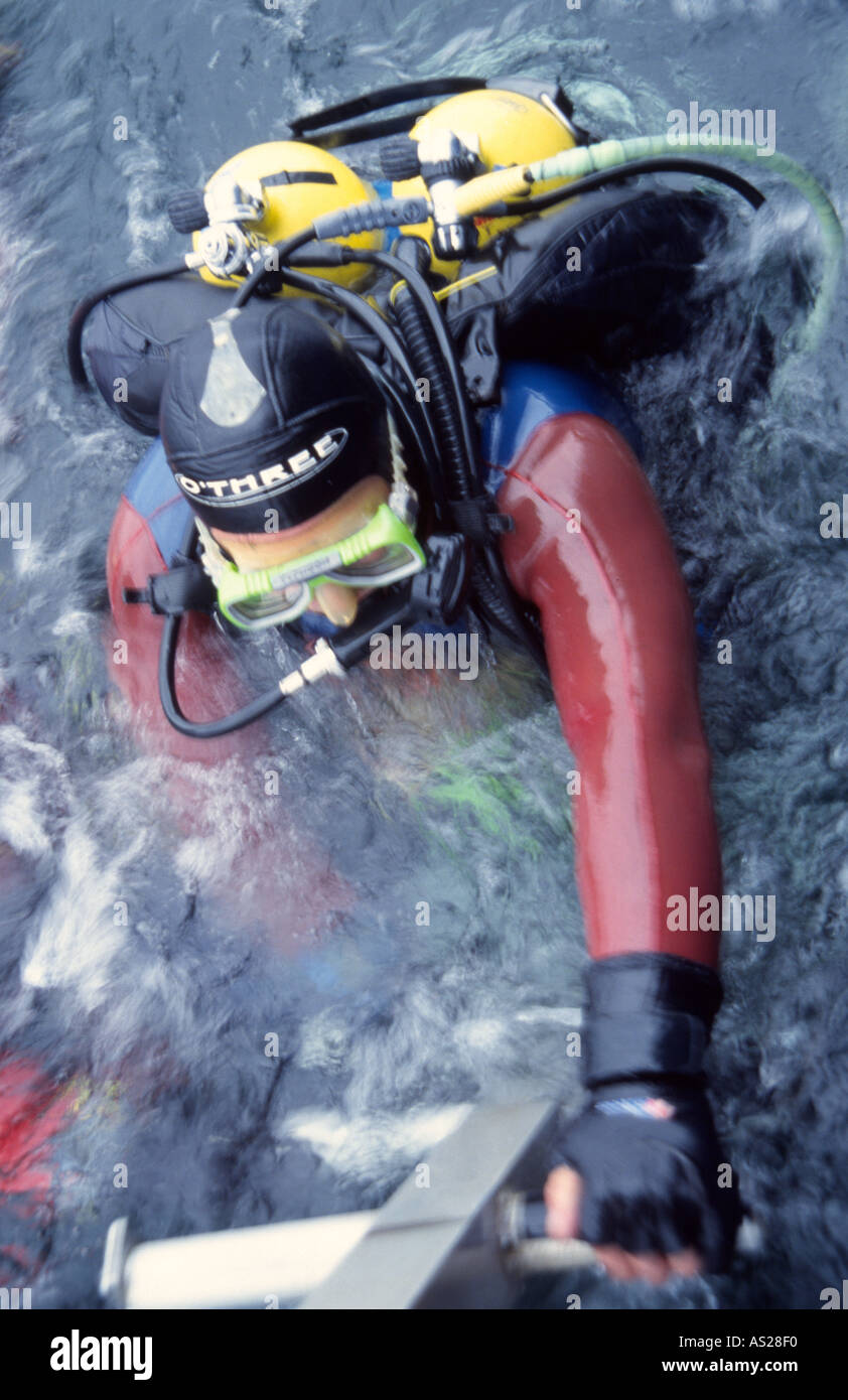 Scuba diver in cold water returning to boat soft focus Stock Photo - Alamy
