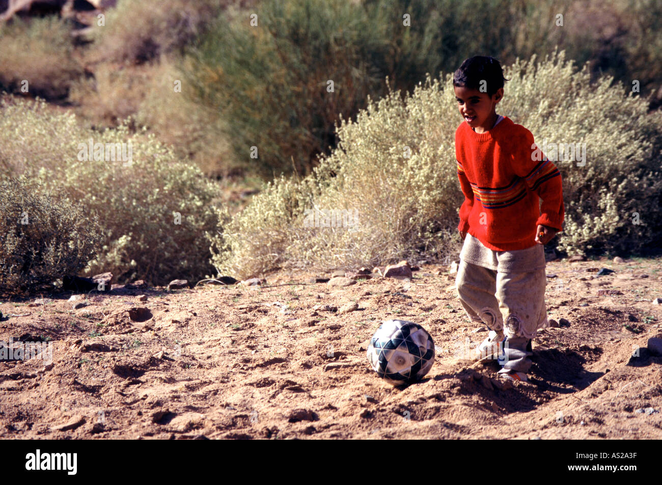 Young Jordanian boy playing football at Wadi Rum in Jordan Stock Photo ...