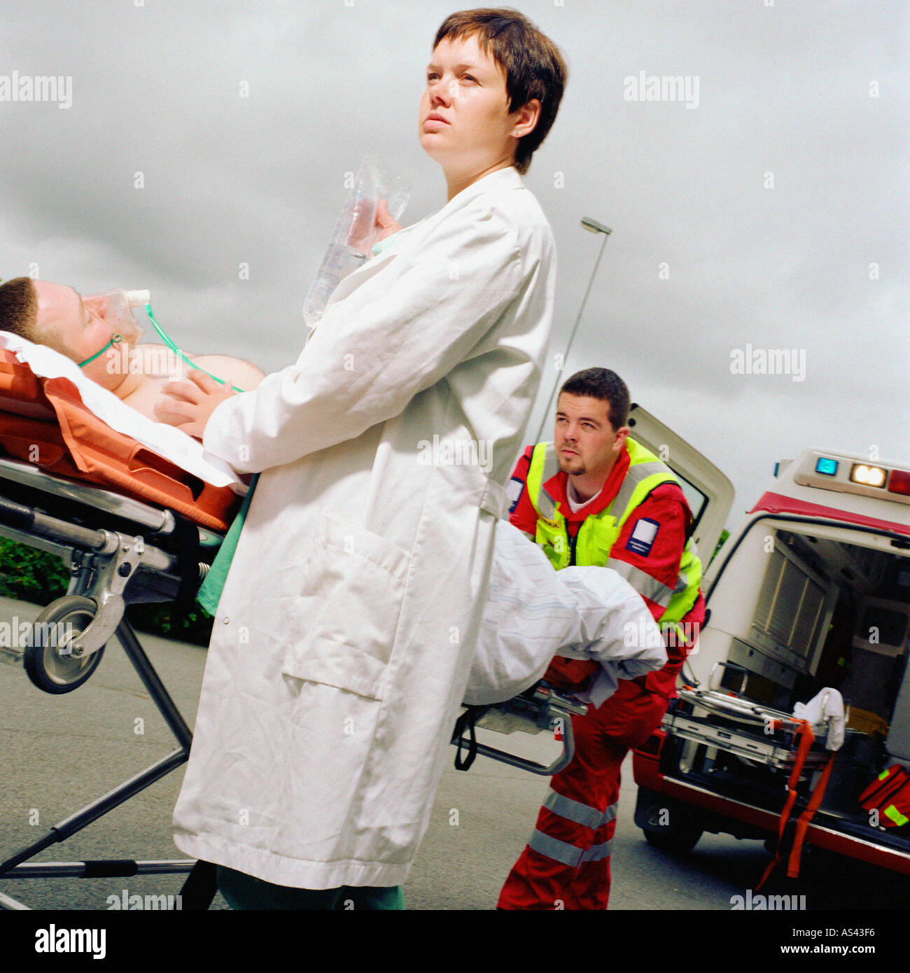 Ambulance staff with patient Stock Photo - Alamy