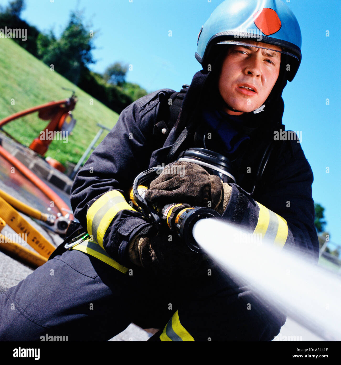 Fireman operating hose Stock Photo - Alamy