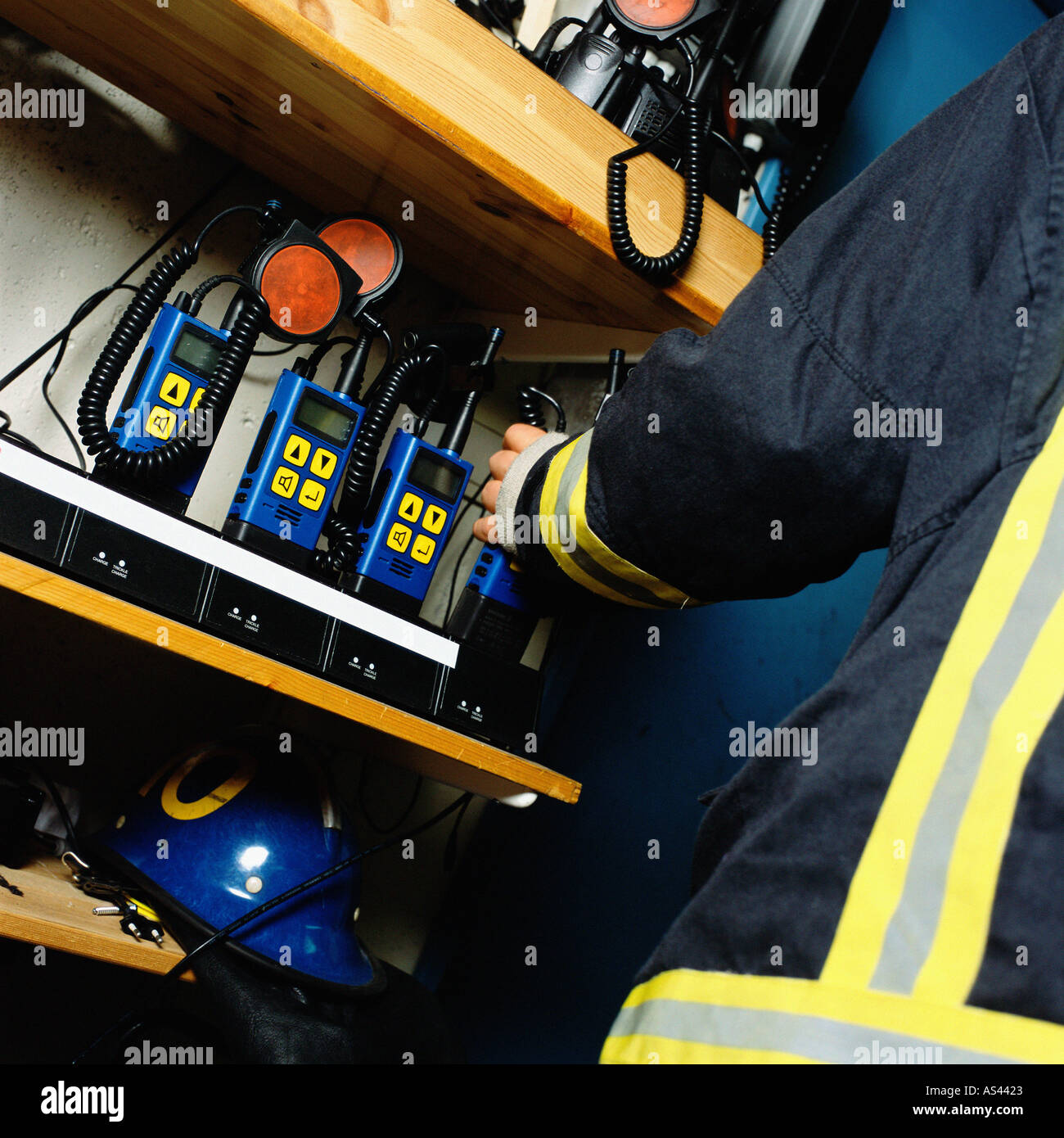 Fireman picking up radio Stock Photo - Alamy