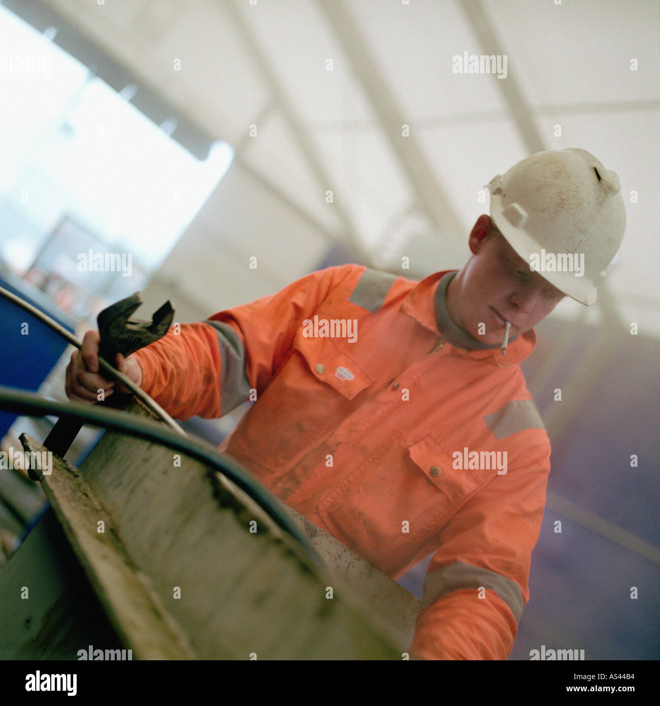 Construction worker holding spanner Stock Photo - Alamy