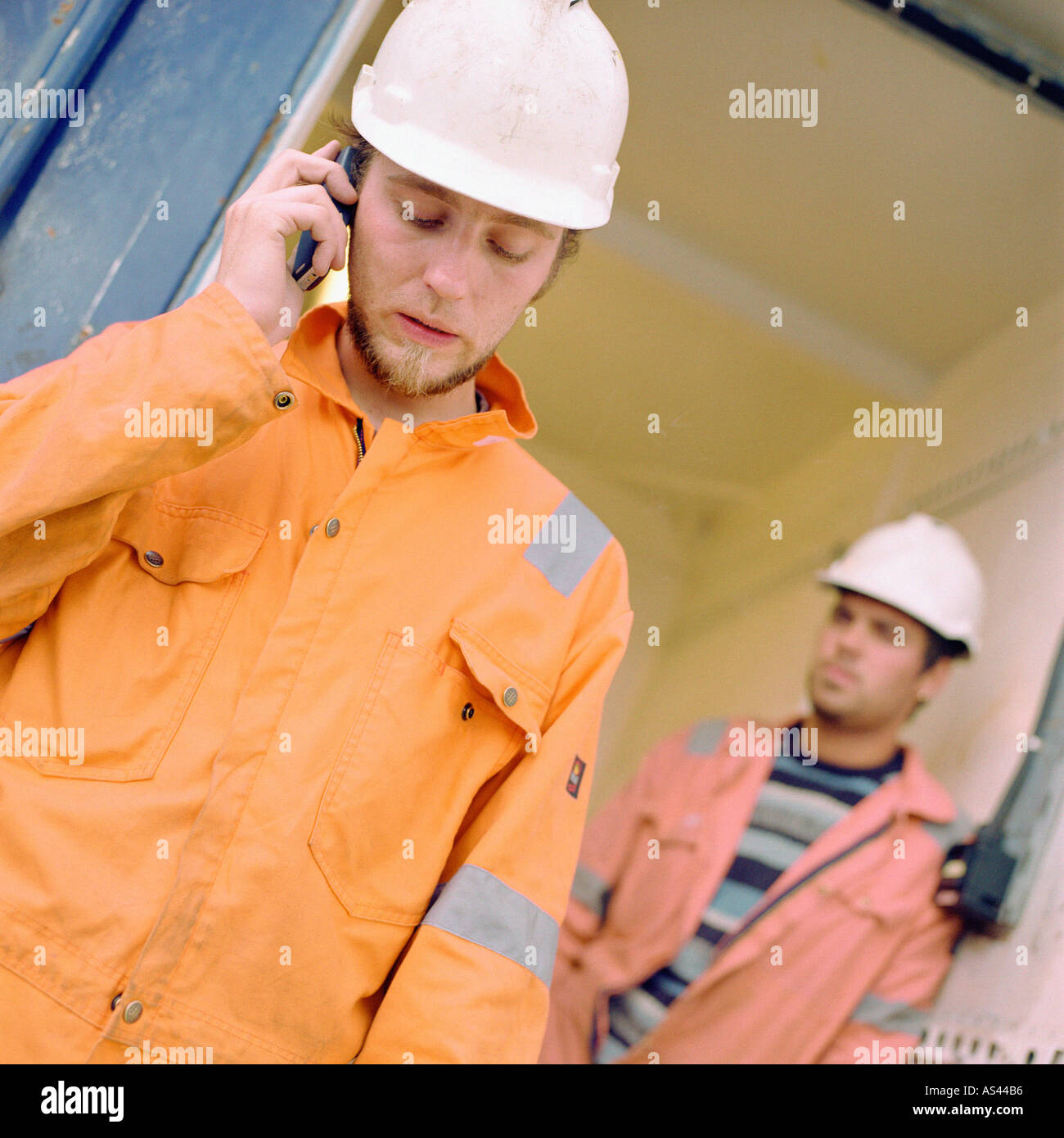 Construction worker using cellular telephone Stock Photo - Alamy