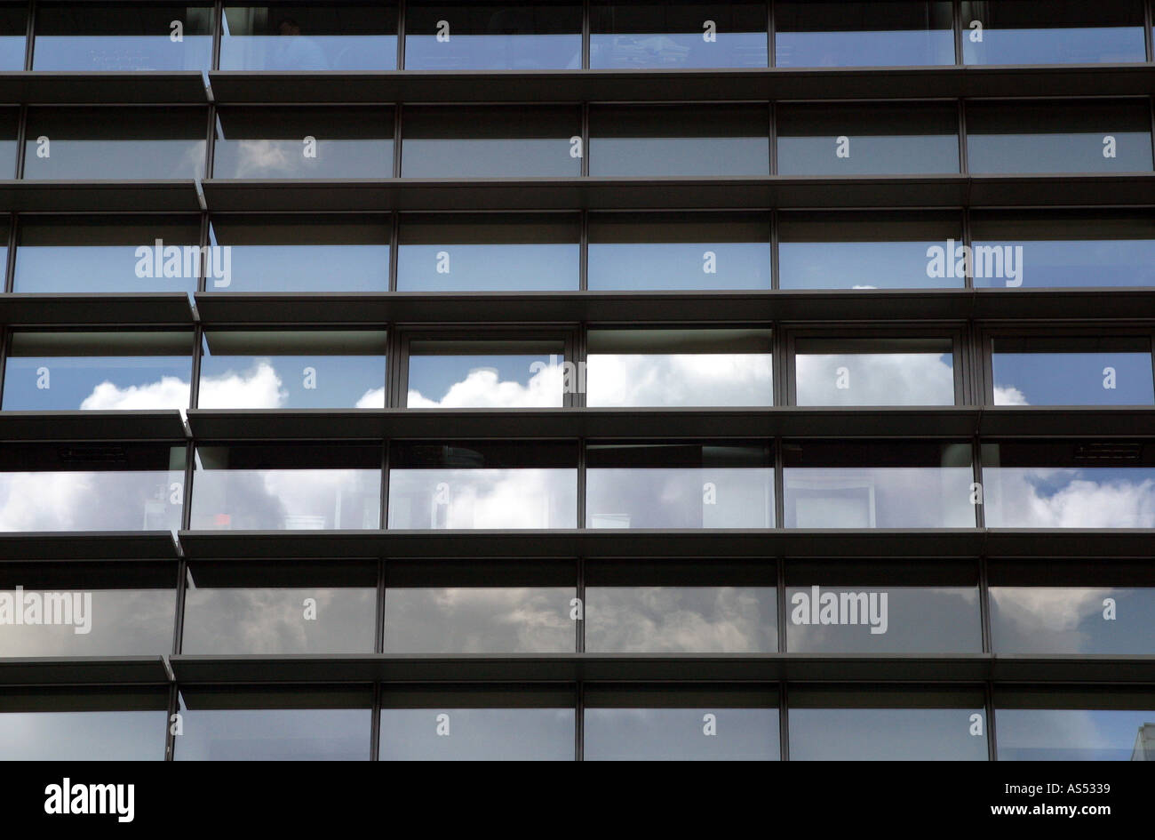 Clouds and sky reflected in the windows of a high rise building Stock ...