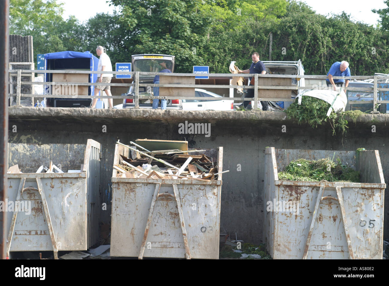 People sorting rubbish into skips at the household waste recycling ...