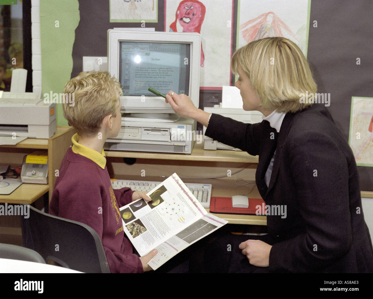 Computer Lesson in the Classroom Teacher and Pupil Stock Photo - Alamy