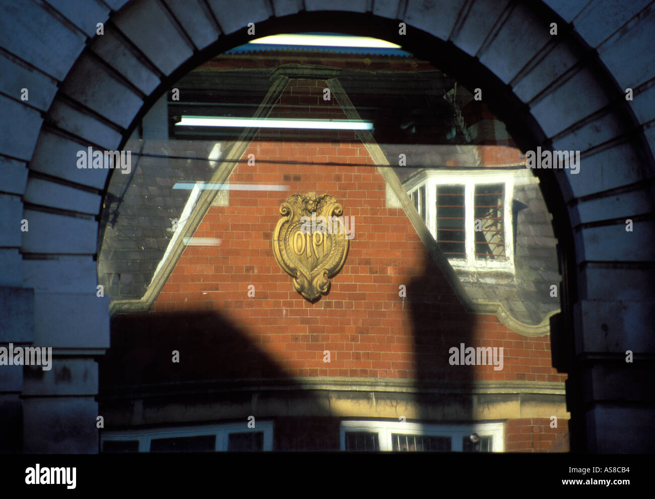 Brick gothic building reflected in the window of a classical building ...