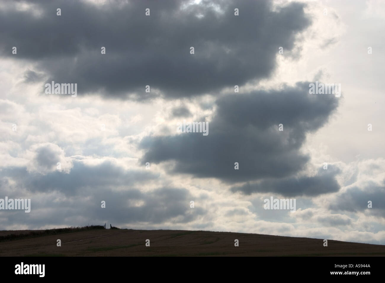 clouds with hill and gate on horizon Stock Photo - Alamy