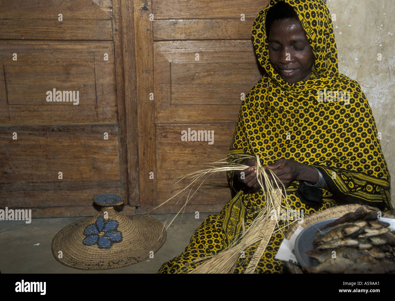 Woman weaving a lid used to keep flies off the food Mafia Island Indian ...