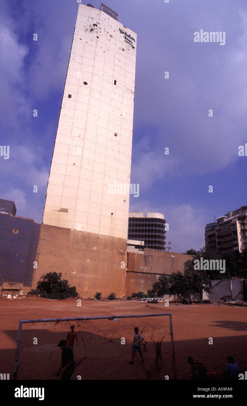 Children playing football amidst the war damaged facade of the Holiday ...