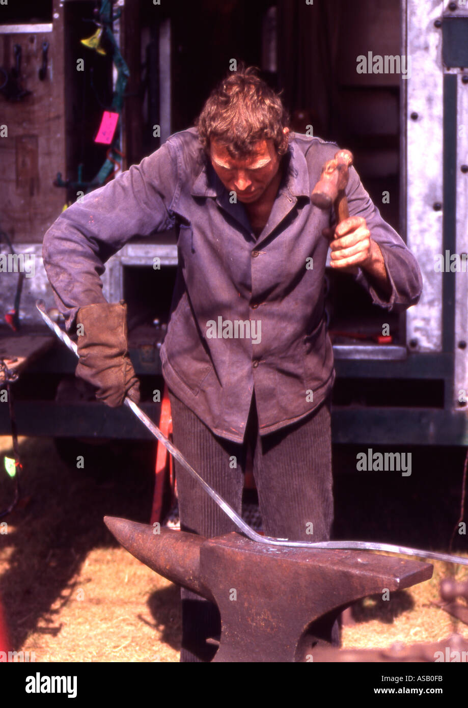 Blacksmith hammers hot iron Stock Photo - Alamy