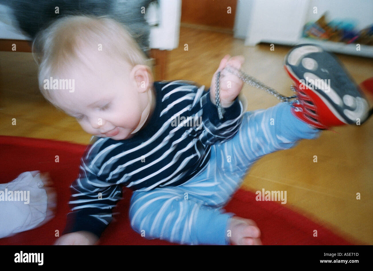 Baby falling while trying to tie the shoe Stock Photo - Alamy
