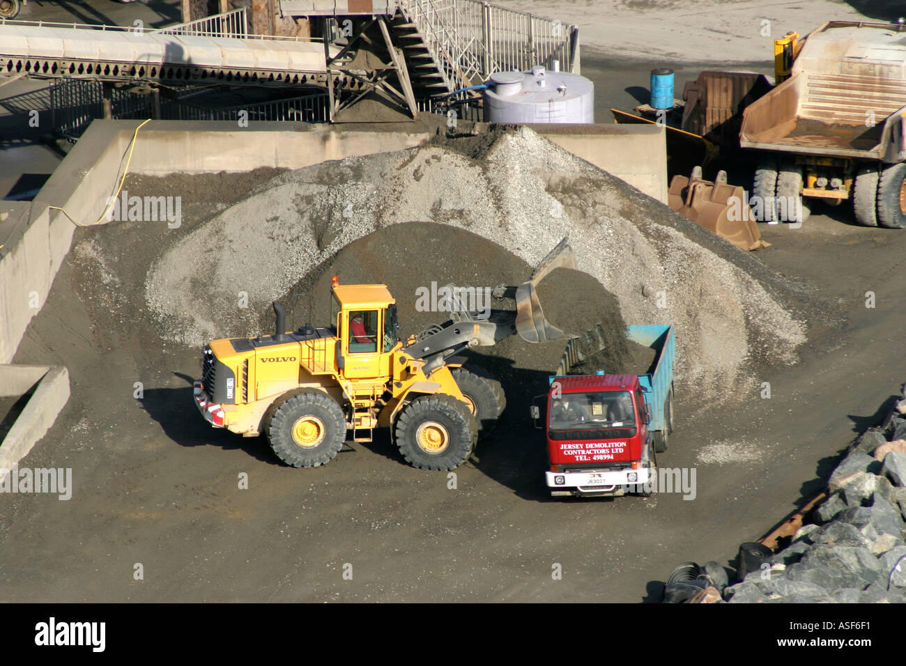 Digger Working at Gravel Storage Yard Loading gravel into truck Stock ...