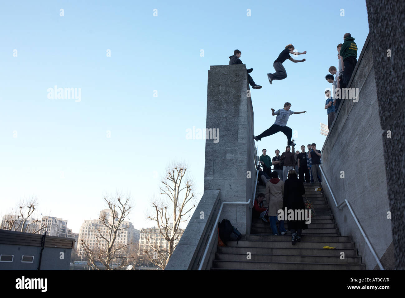 Leaping fearlessly across the gaps of high walls teenage boys practice ...