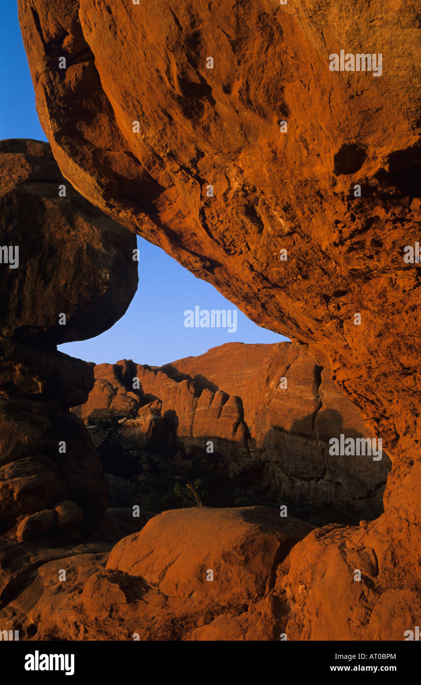 A sandstone window glows red in sunset light, Arches National Park ...