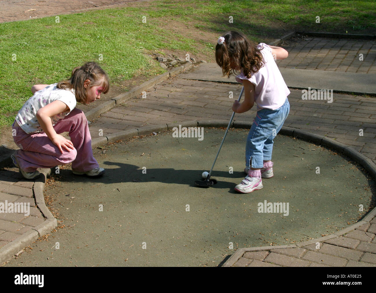 Young girls playing crazy golf Stock Photo - Alamy