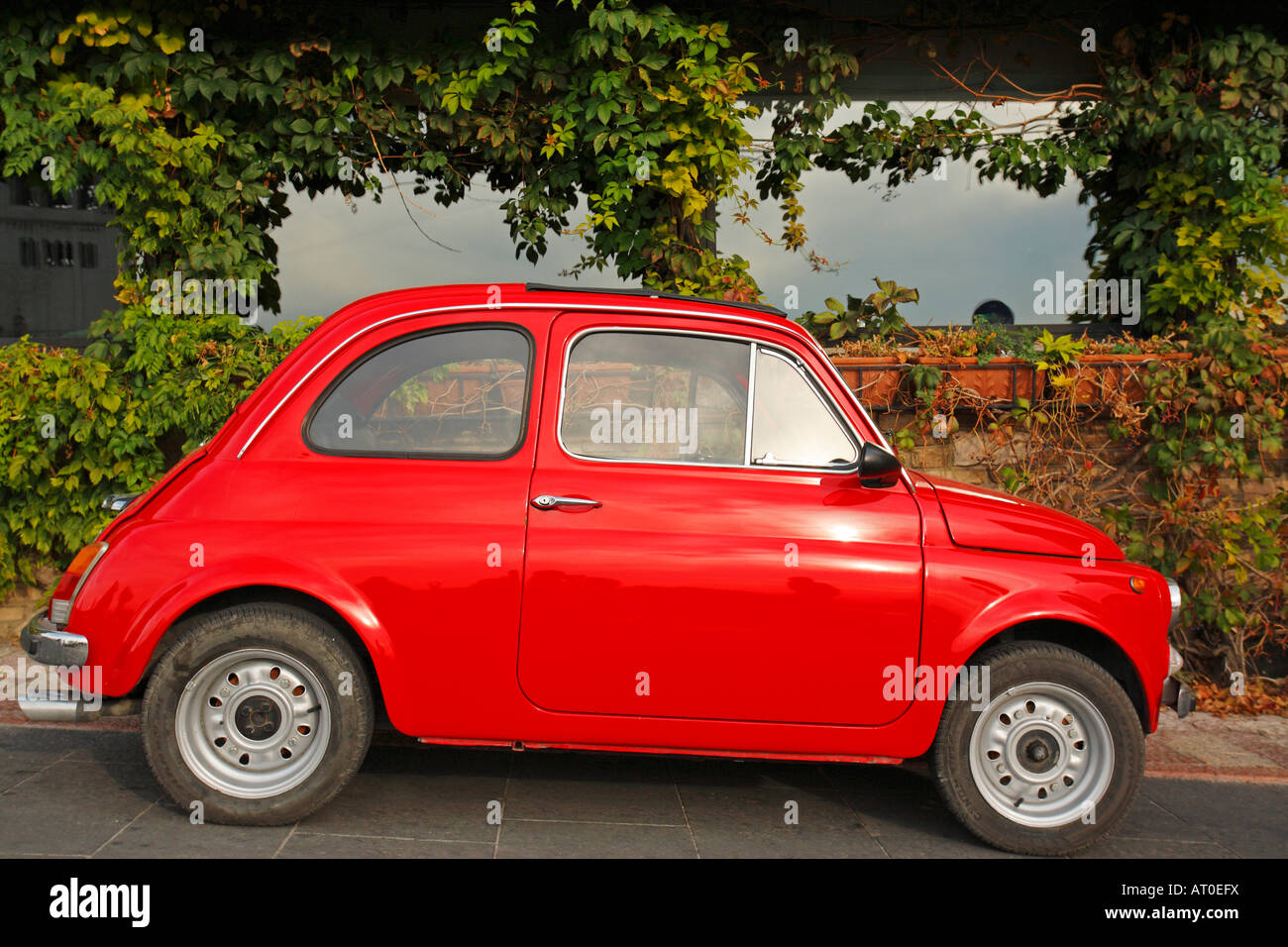 Small red car parked on the street in Assisi, Italy Stock Photo - Alamy