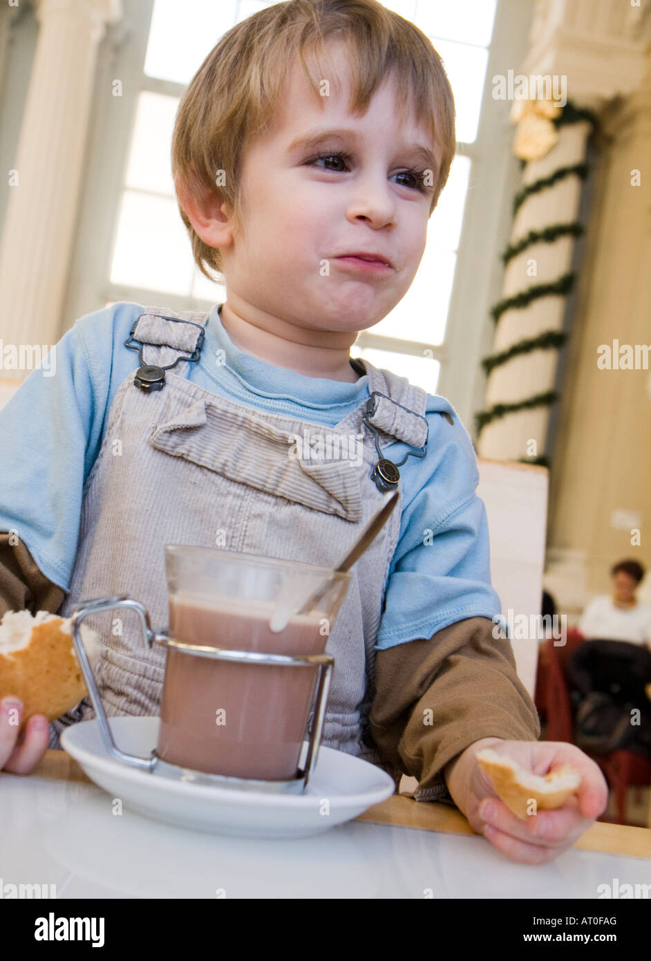 little boy having an afternoon snack and hot chocolate Stock Photo - Alamy