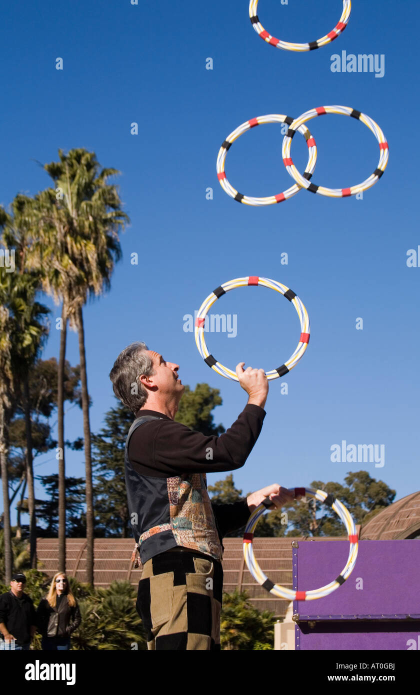 A street performer juggles hoops in a beautiful park setting Stock ...
