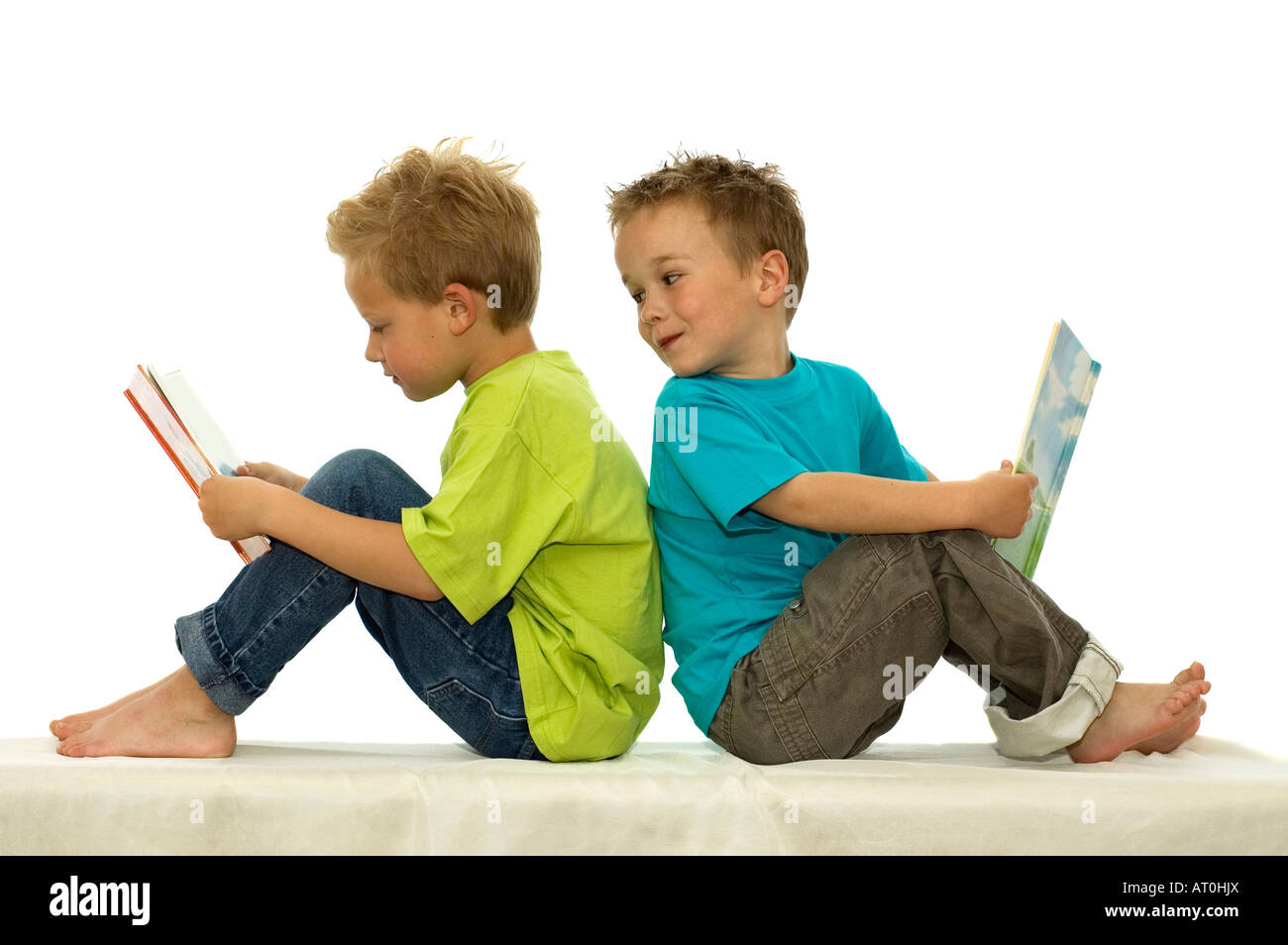 Two friends reading a book one boy looks at the book of the other ...