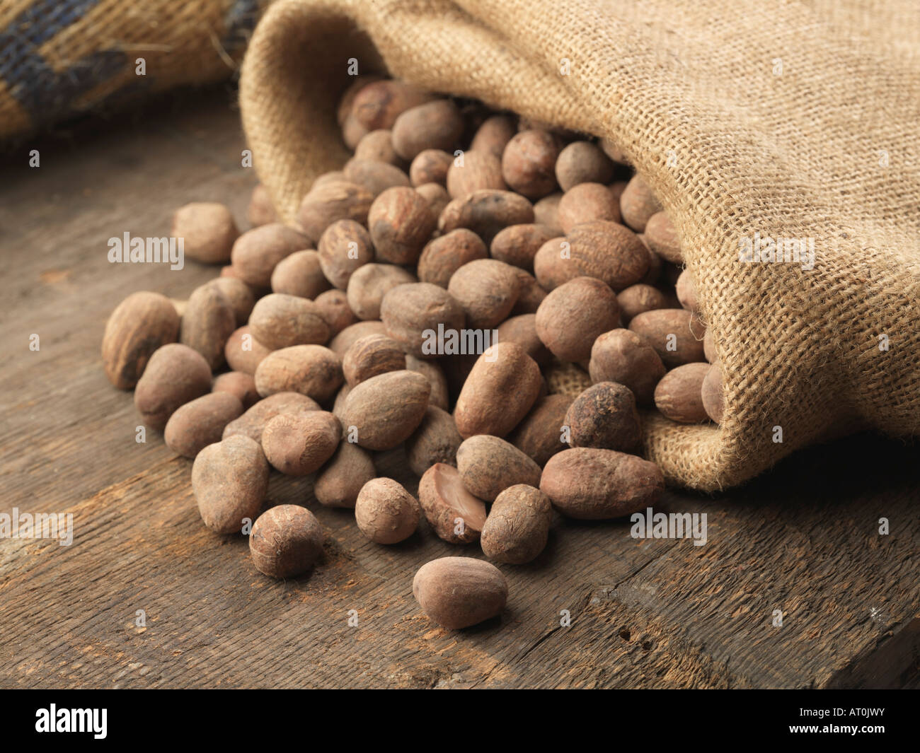 Shea Nuts pouring out of a hessian bag onto a wooden background Stock ...
