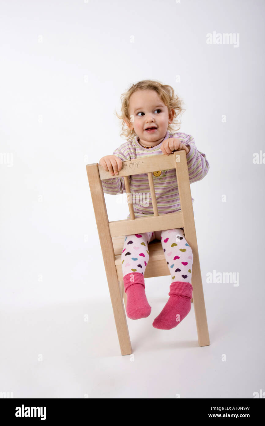 happy little girl sitting on chair Stock Photo - Alamy
