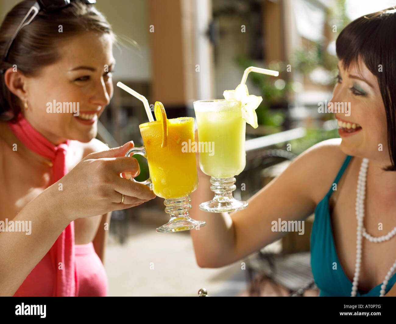 two women having fruit juice at cafe Stock Photo - Alamy