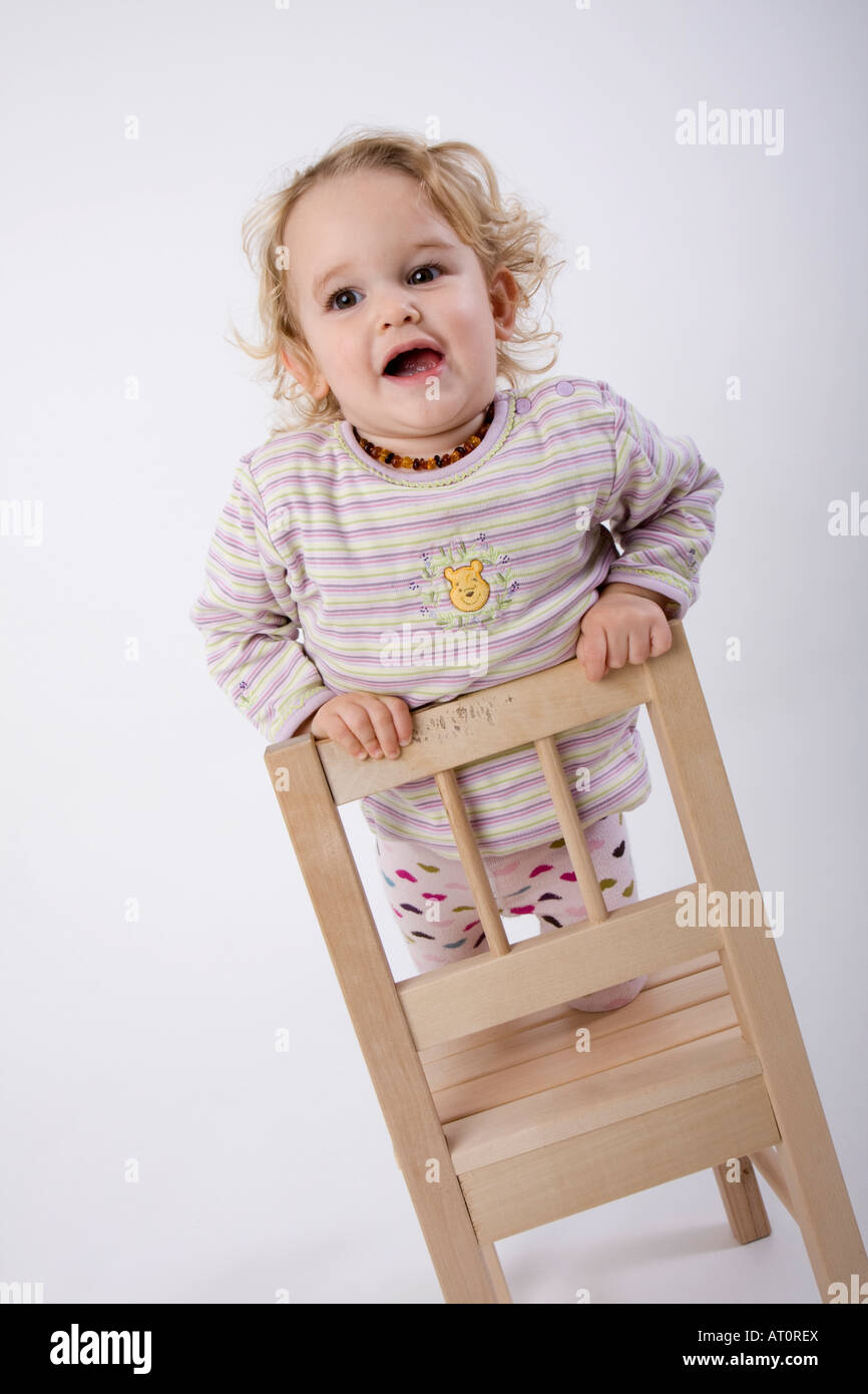 happy little girl standing on chair Stock Photo - Alamy