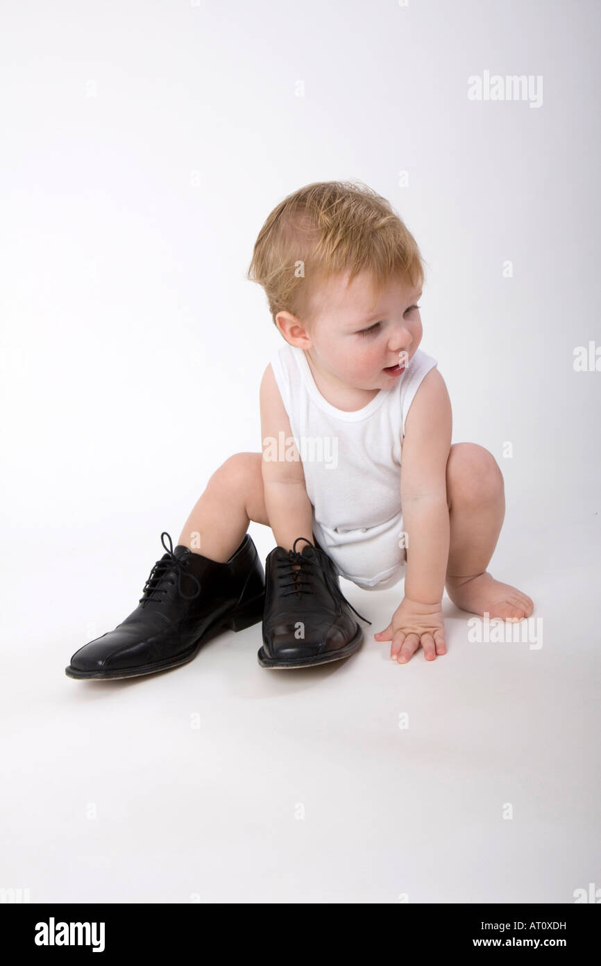 little boy with far too big black shoes Stock Photo - Alamy