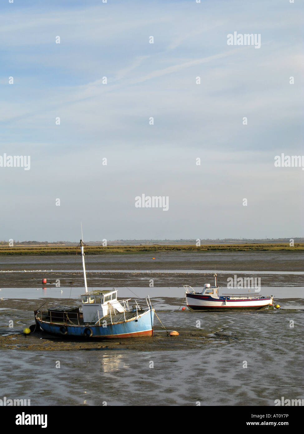 Boats moored on the mud on the Blackwater Estuary at Maldon in Essex ...