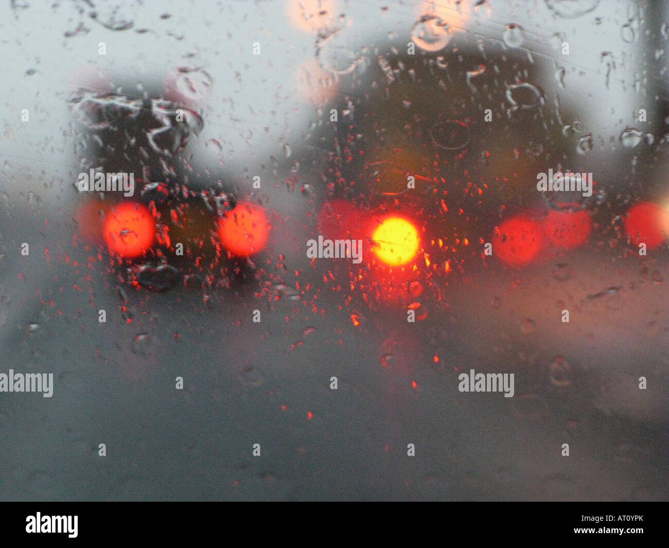 The view out of a car s windscreen of traffic driving through the rain ...