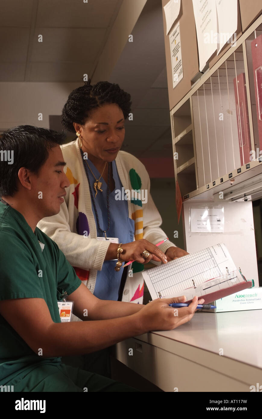 Heath Care Two nurses look over paperwork at the nurses station Stock ...